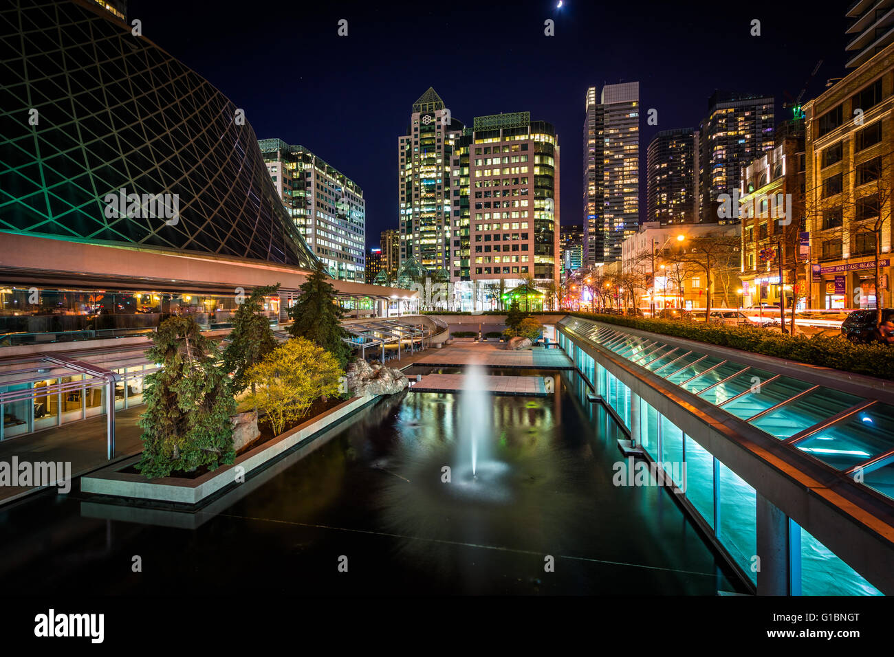 Fountains and modern buildings at David Pecaut Square at night, in ...