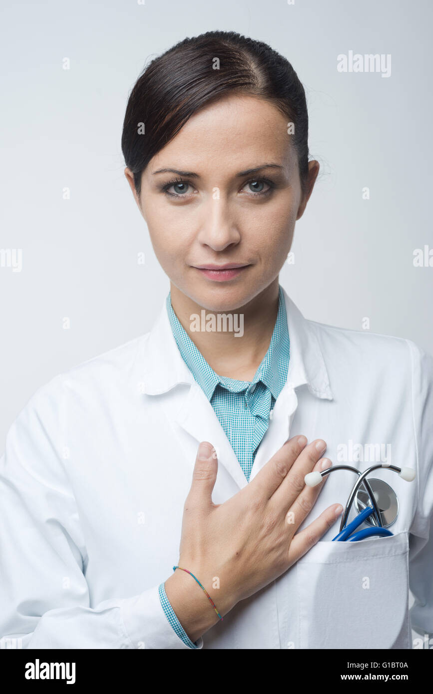 Attractive female cardiologist with stethoscope and lab coat, touching ...