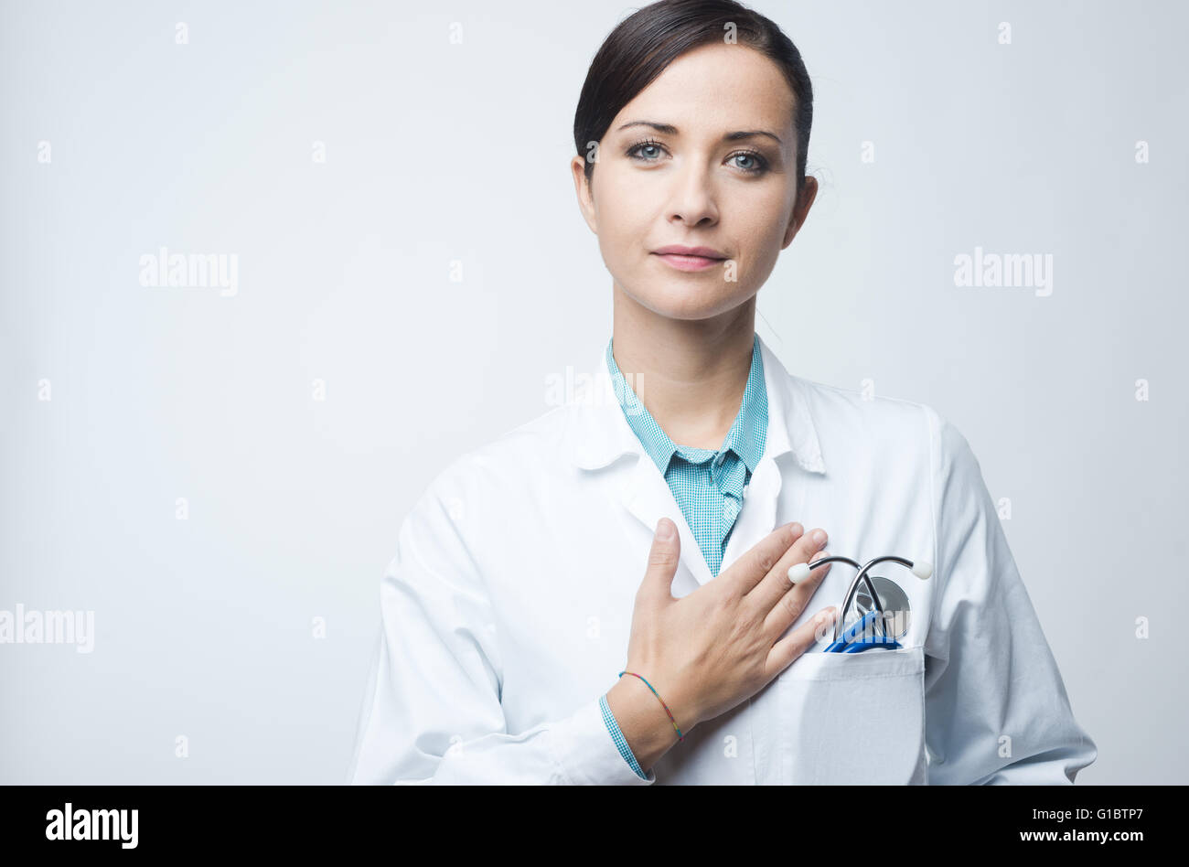 Attractive female cardiologist with stethoscope and lab coat, touching ...