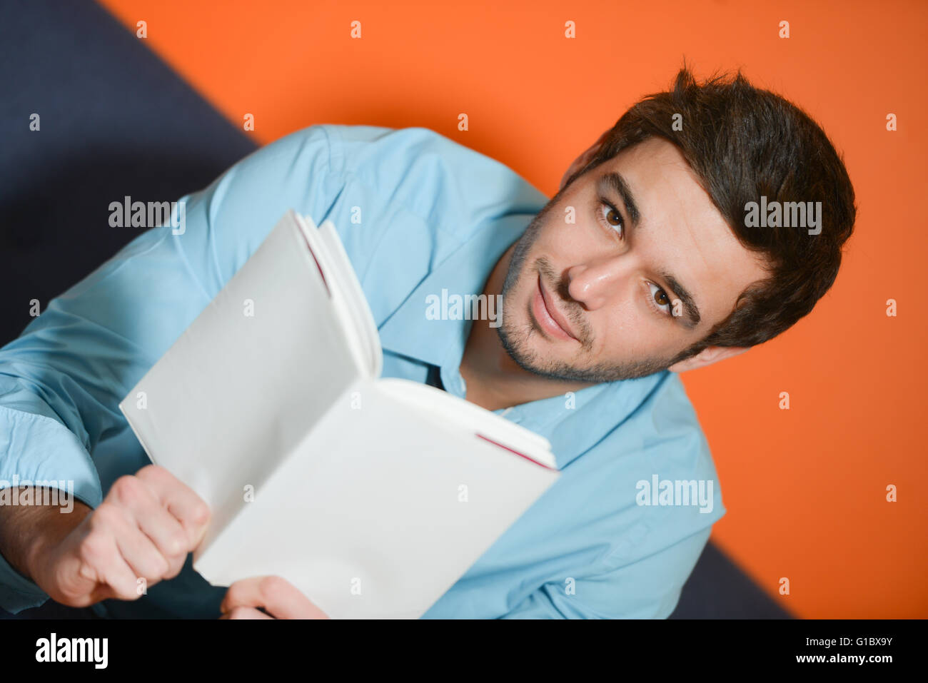 Man at home reading book Stock Photo - Alamy