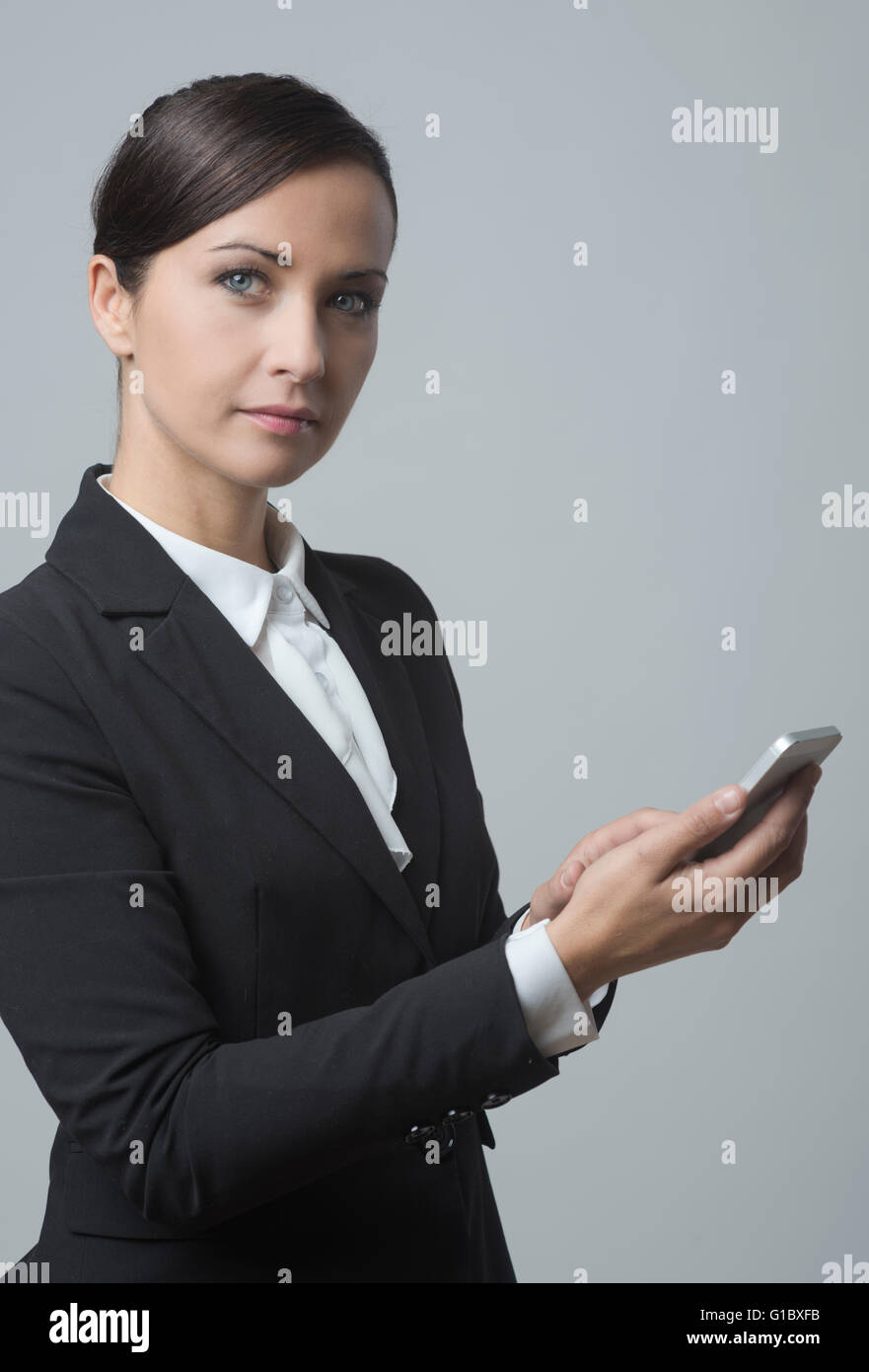 Smiling confident business woman using touch screen mobile phone Stock ...