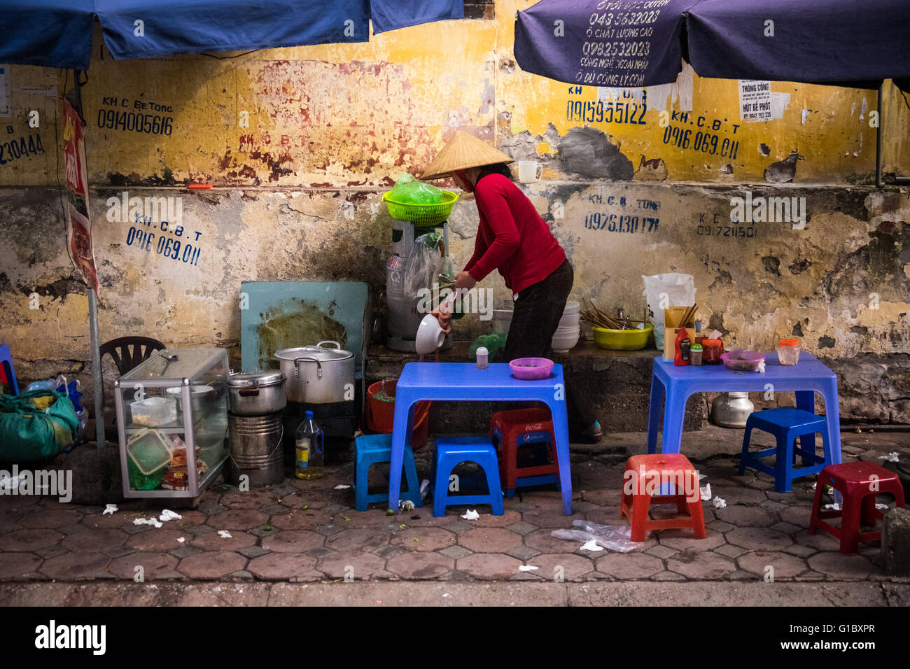 A woman selling Pho noodle soup from her pavement stall in Hanoi Stock ...
