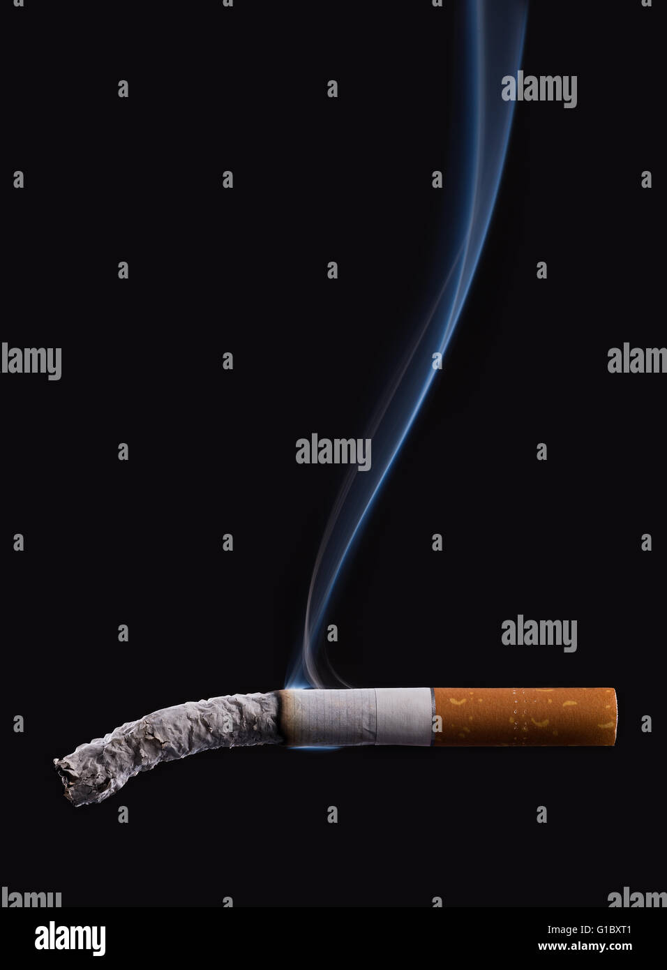 Cigarette burning on dark black background with smoke, stop smoking ...