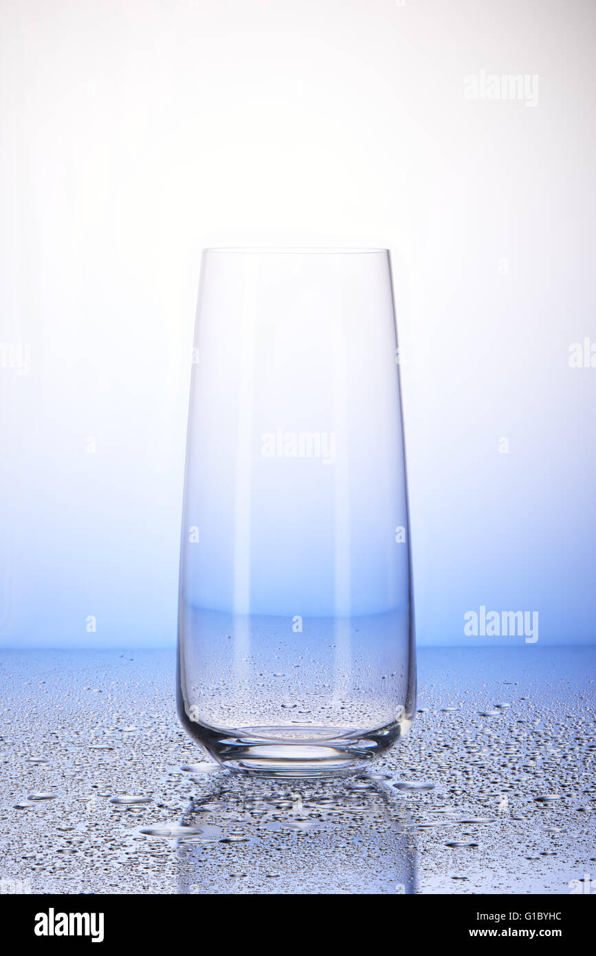 Empty drinking glass with reflection on drops of water on white and ...