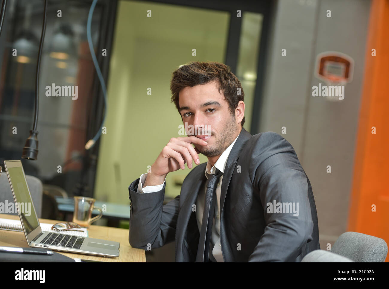 Portrait of smiling Businessman posing in coworking office Stock Photo ...