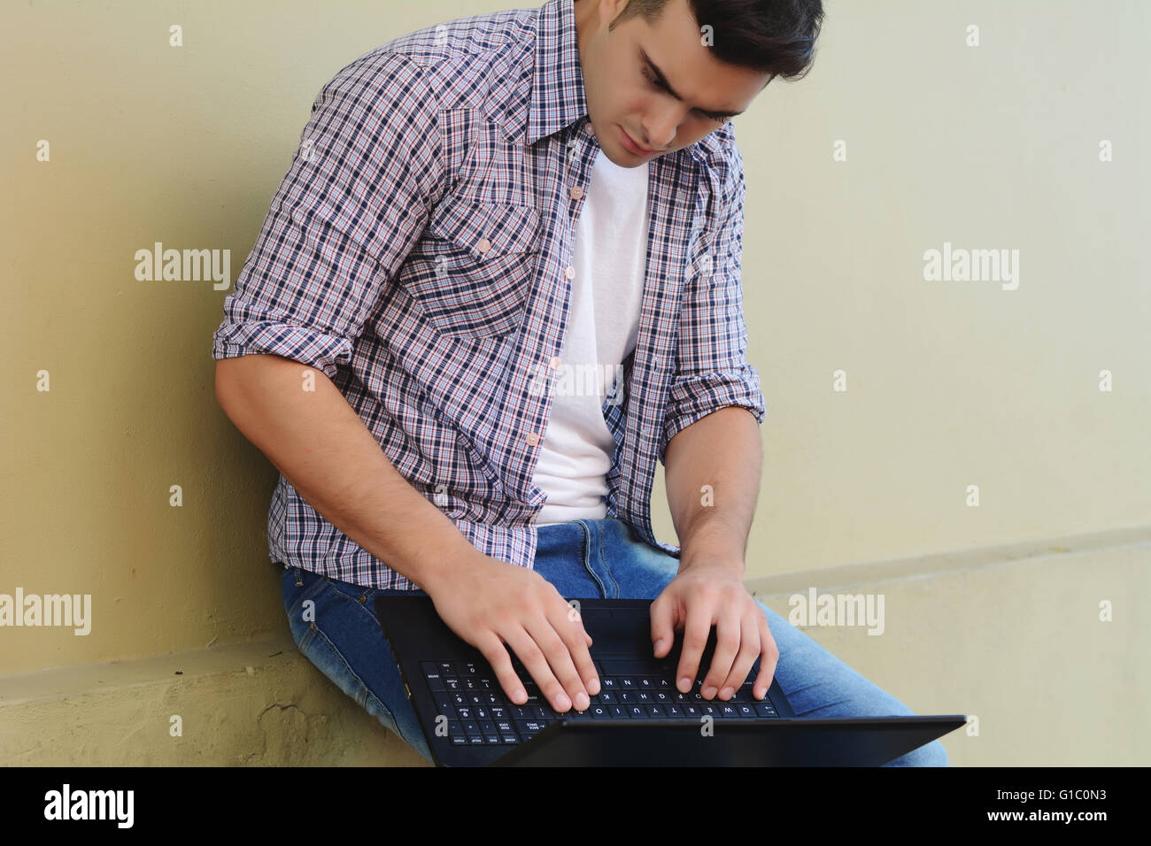 Young handsome man using his laptop outdoors Stock Photo - Alamy