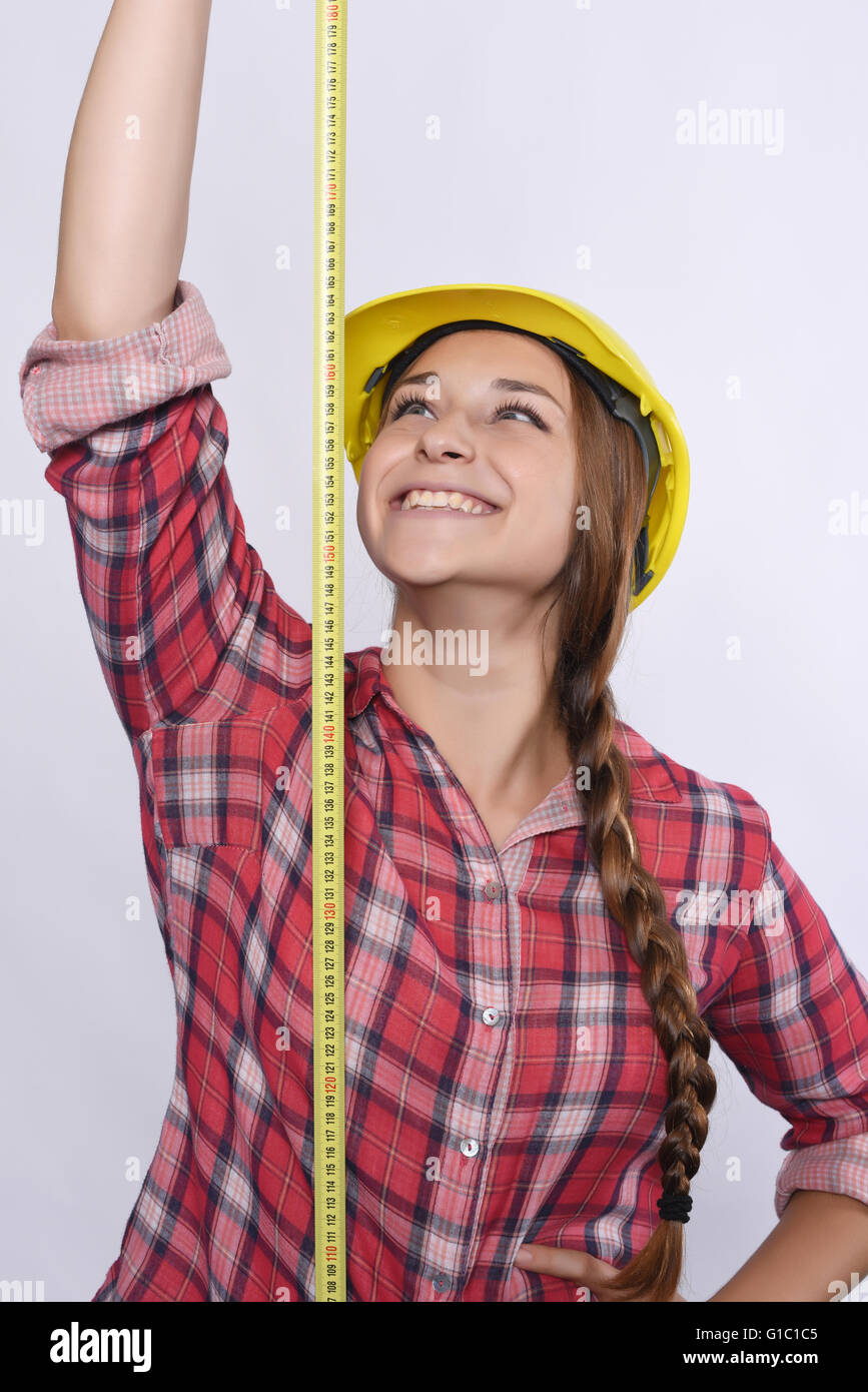 Close up of beautiful woman construction worker taking measures with a ...