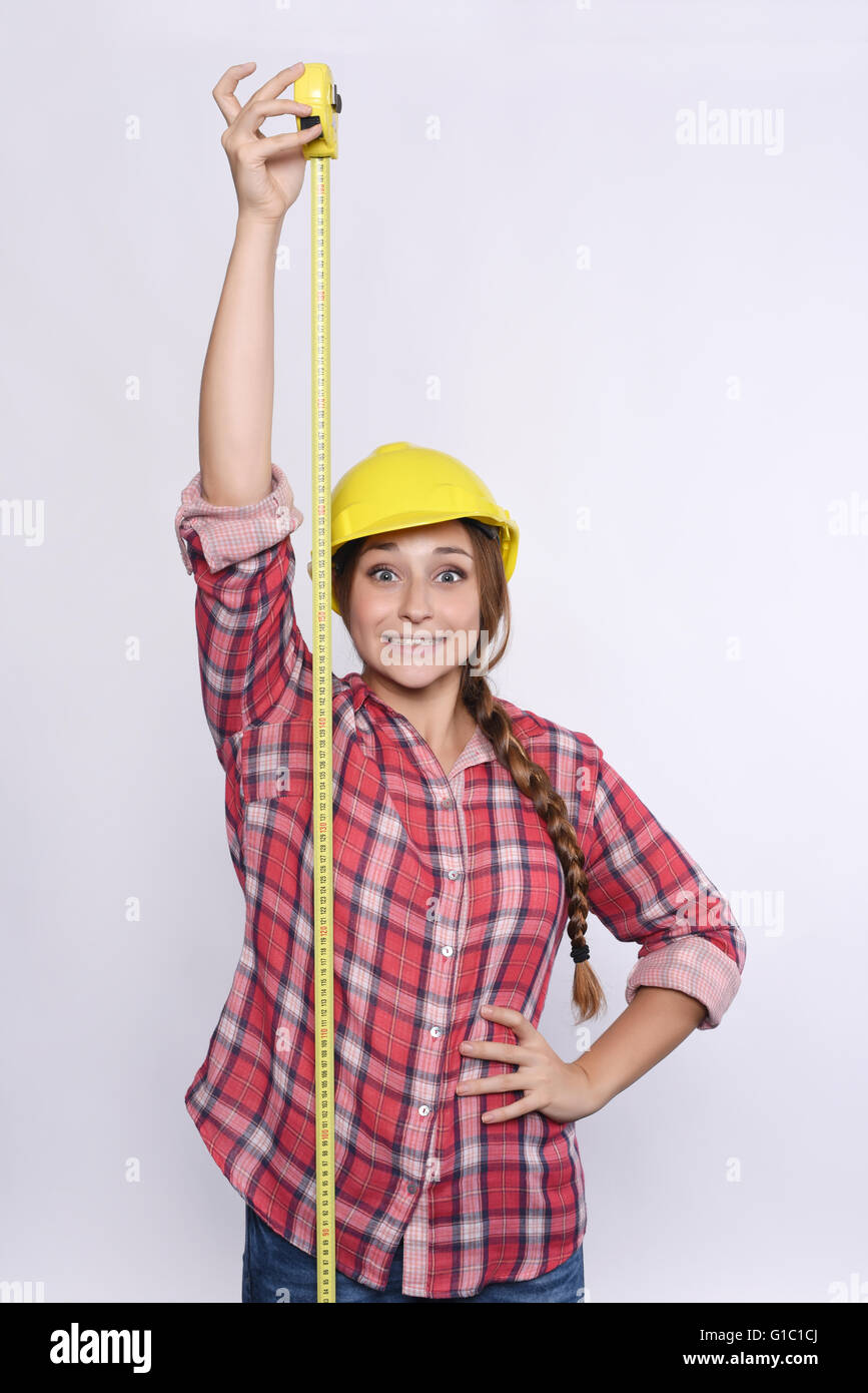 Portrait of beautiful woman construction worker taking measures with a ...