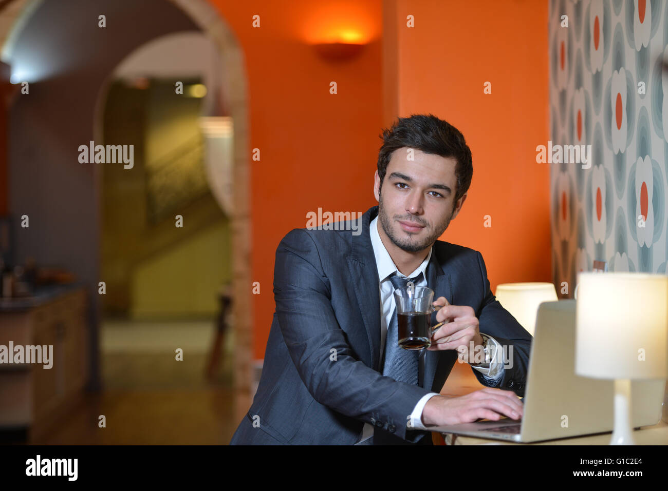 Handsome business man in restaurant drinking coffee Stock Photo - Alamy