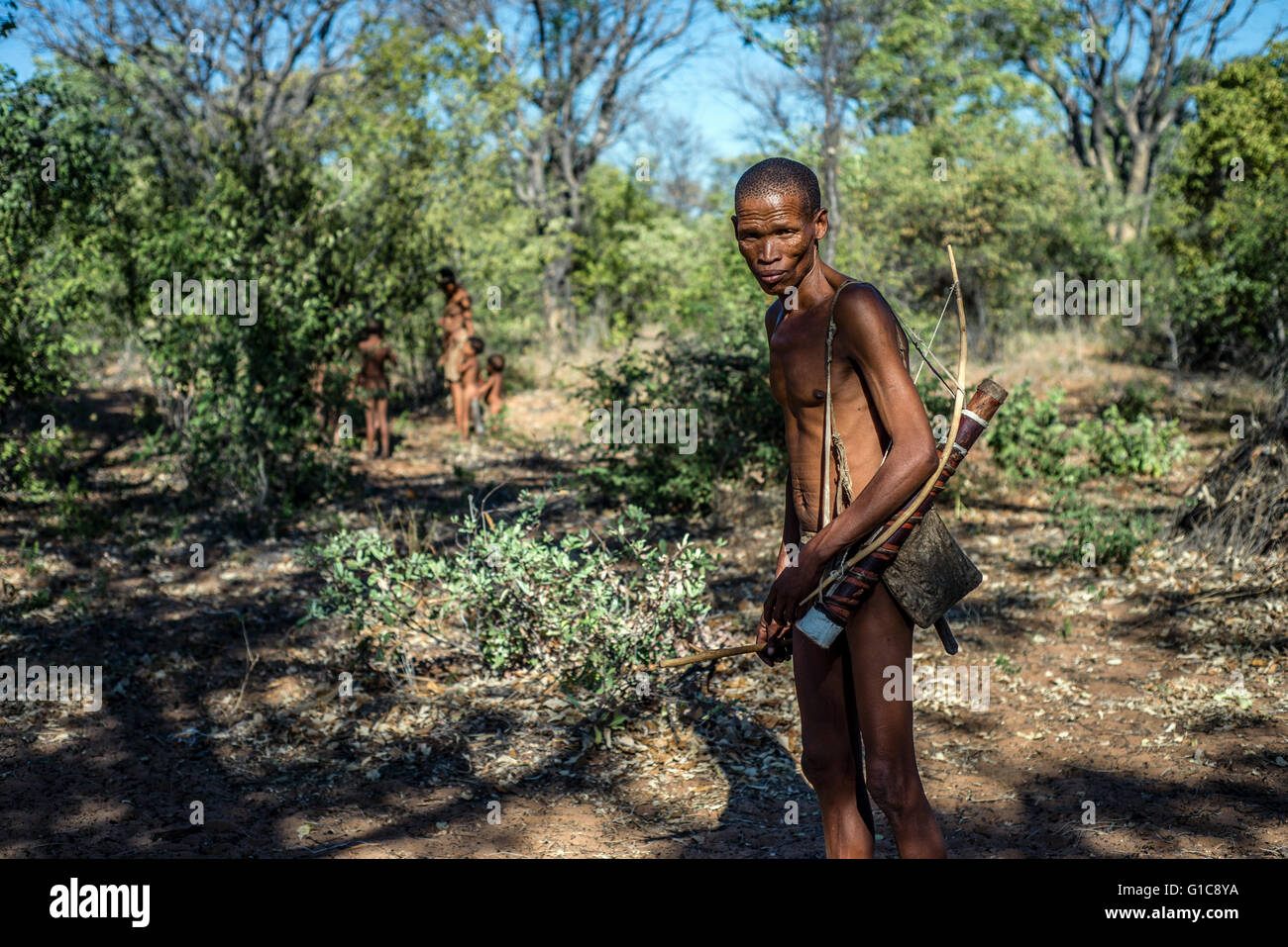 A San man checking animals' footsteps on sand during hunting in the ...