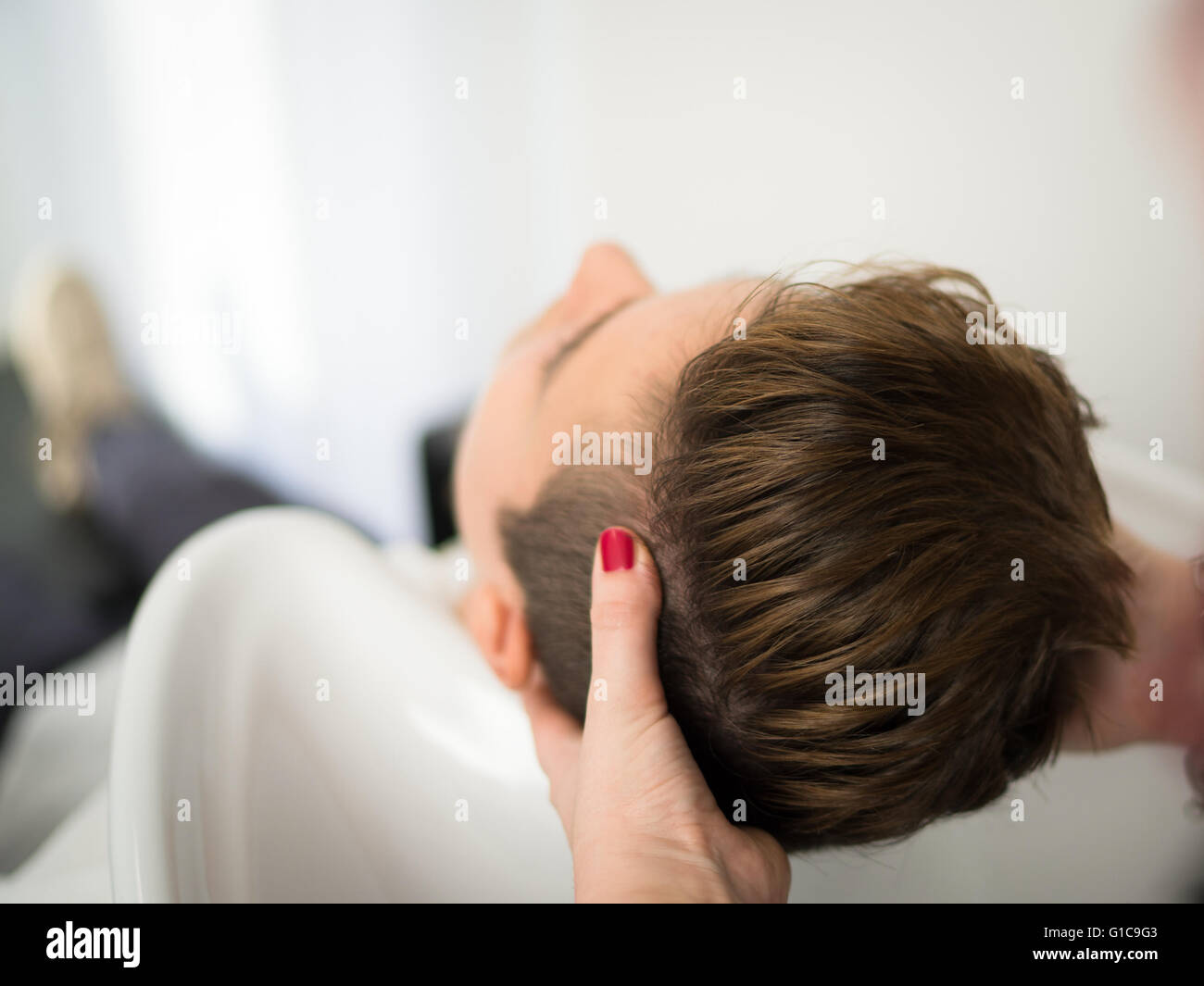 Relaxing head massage to a young boy in a spa Stock Photo - Alamy