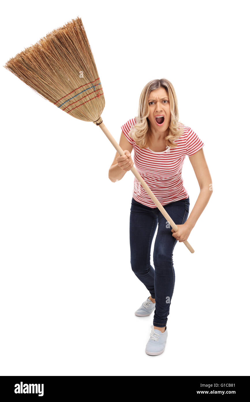 Vertical shot of an angry woman threatening with a broom and shouting ...