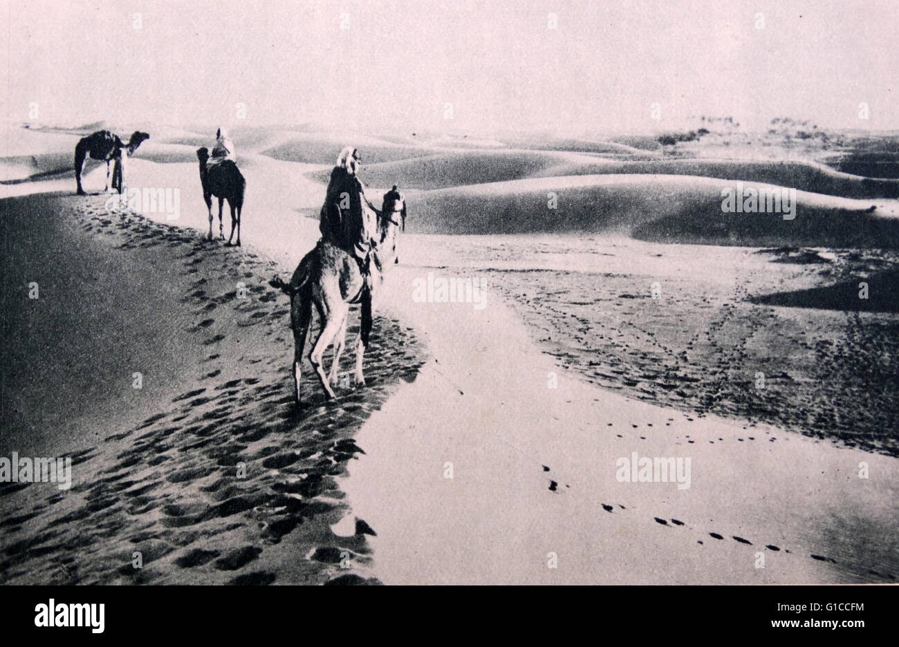 North African Arabs cross the Sahara desert by camel 1930 Stock Photo ...