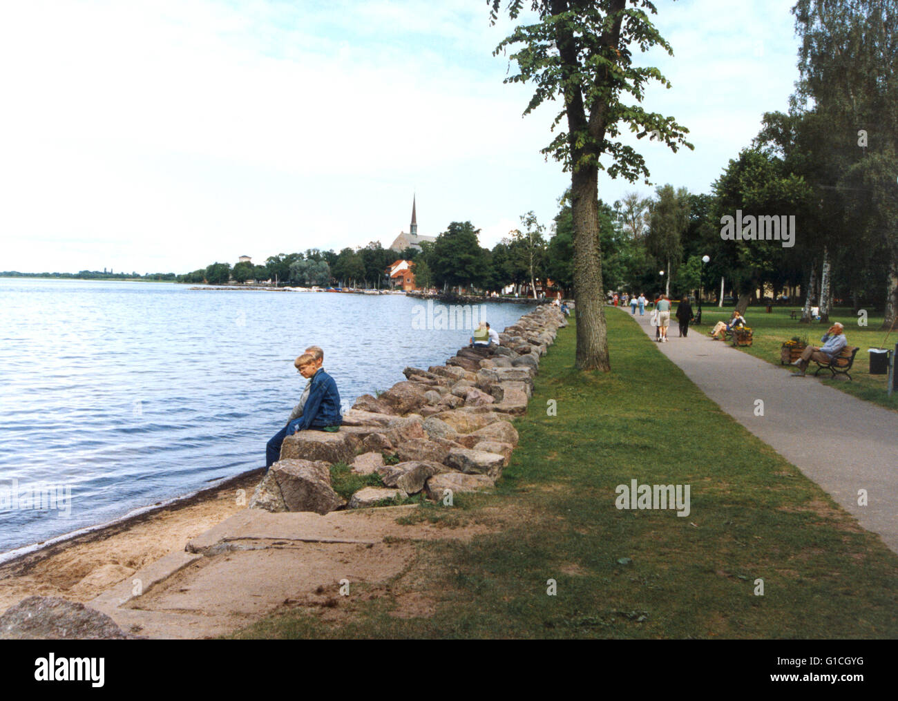 People sitting at the water´s edge and rest Stock Photo - Alamy