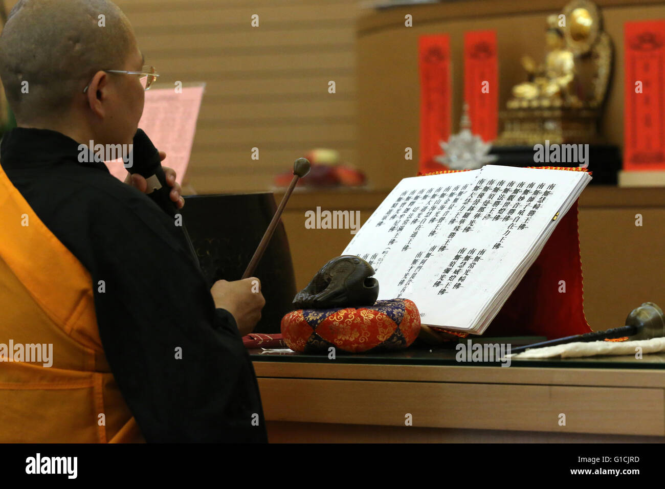 Fo Guang Shan temple. Buddhist ceremony. Monk playing on a wooden fish ...