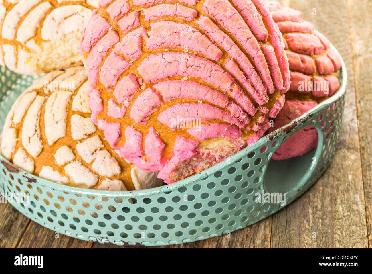 Homemade pan dulche with white, yellow, and pink icing Stock Photo - Alamy