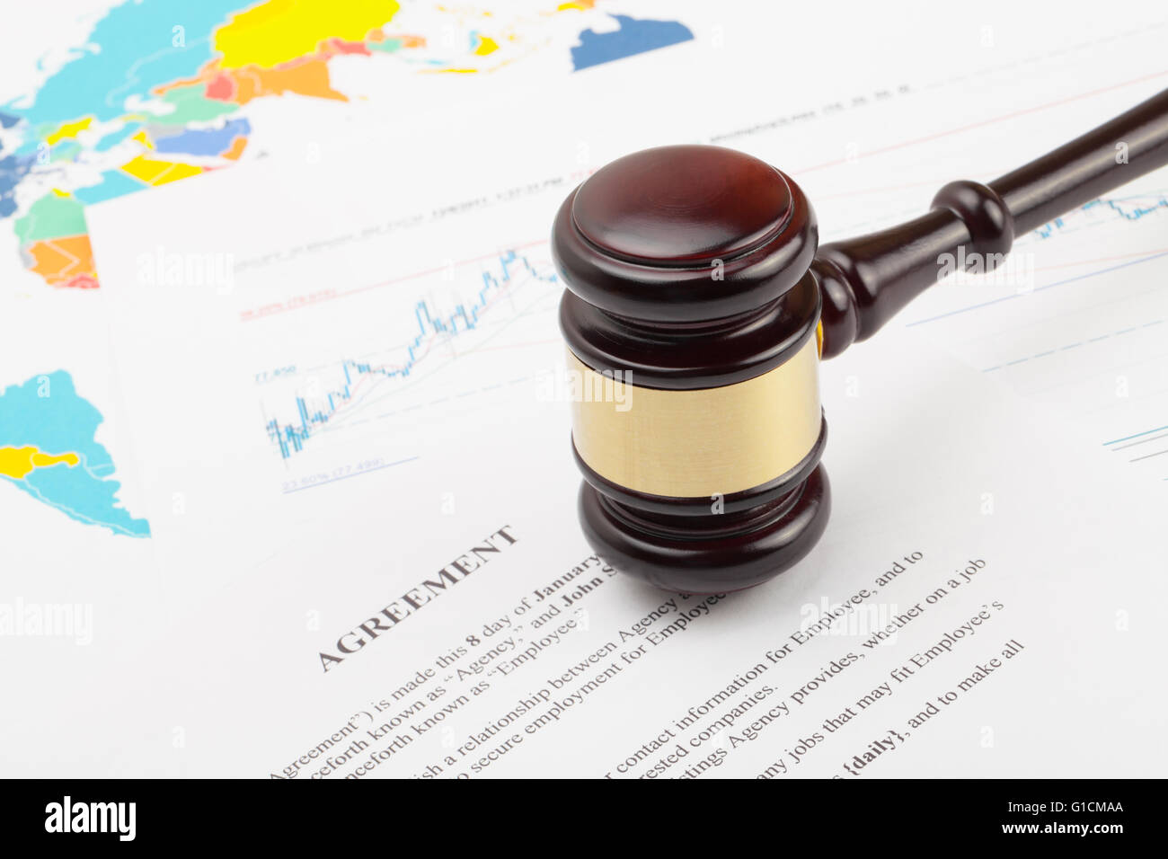 Wooden judge's gavel over agreement document - close up studio shot ...