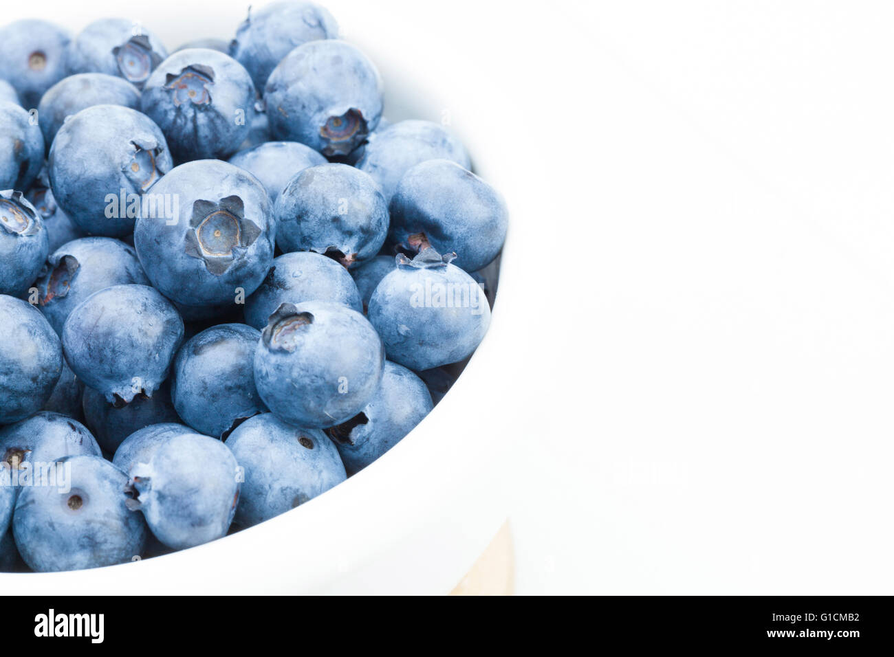 Freshly picked blueberries in white bowl - close up shot with focus on ...