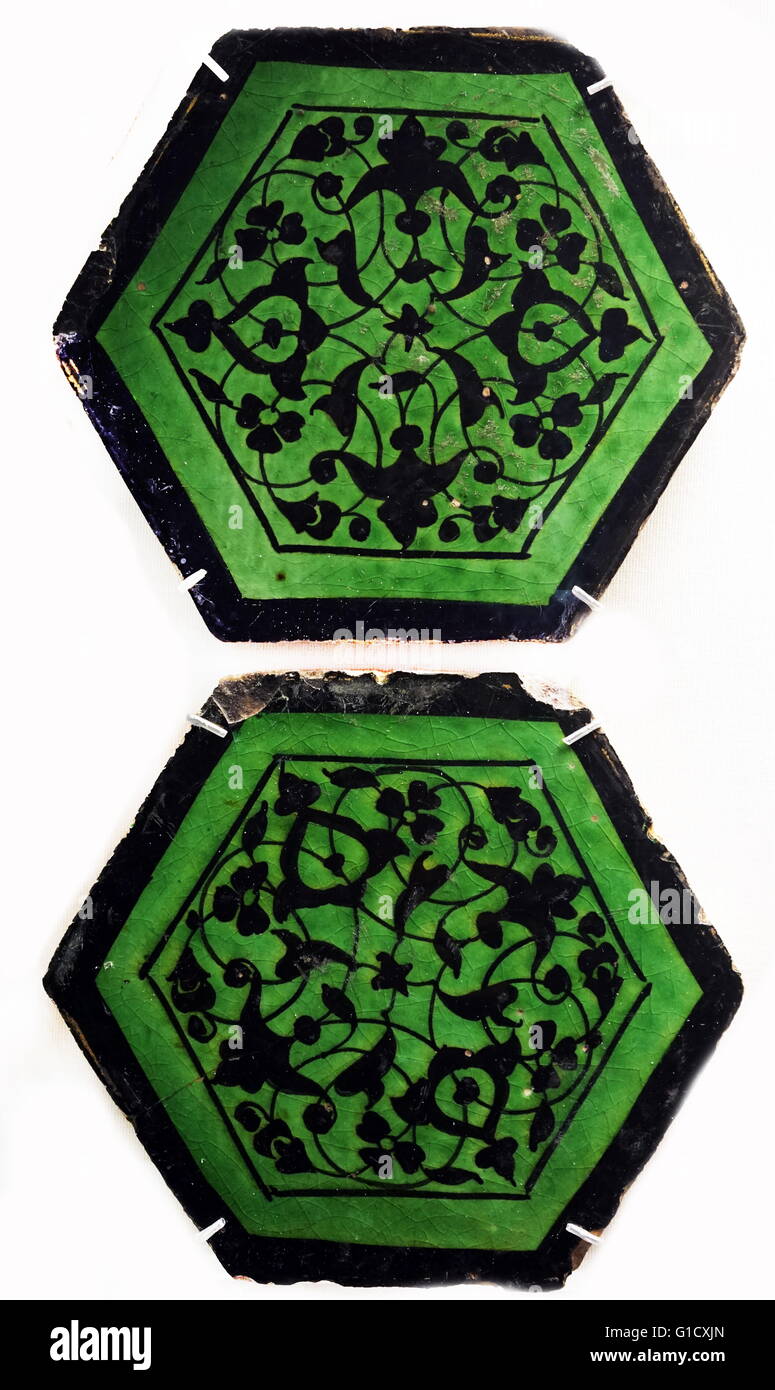 Hexagonal tiles painted with black cruciform arabesque scrolls and ...