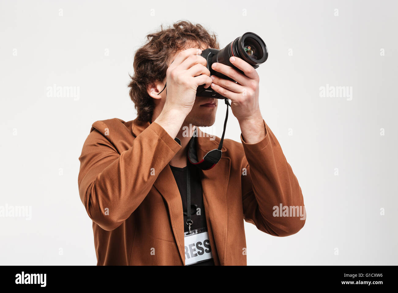 Man with curly hair photographing something on camera isolated on a ...
