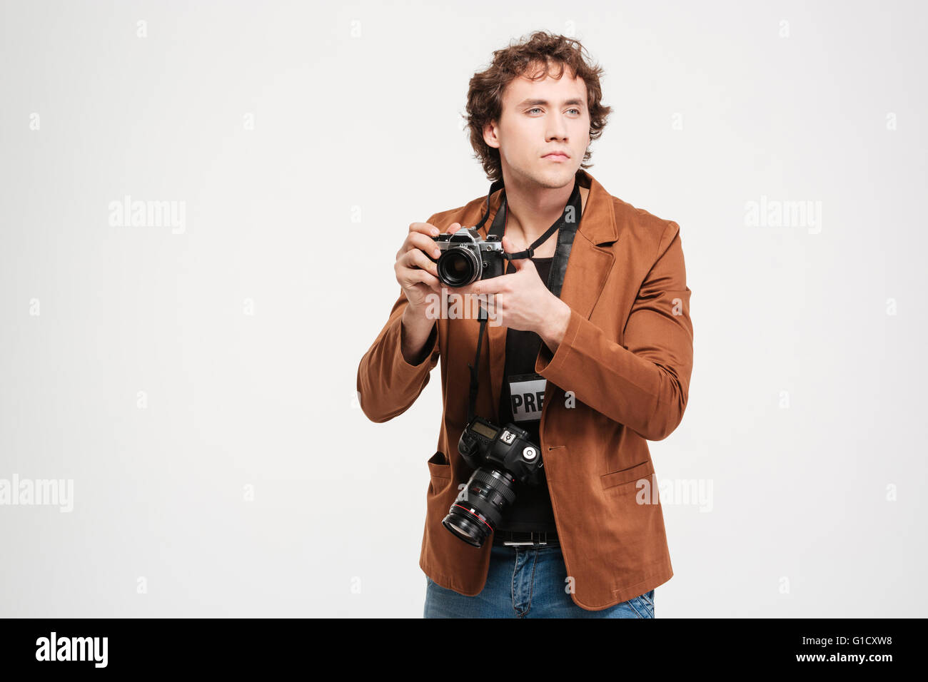 Male reporter holding camera and looking away isolated on a white ...