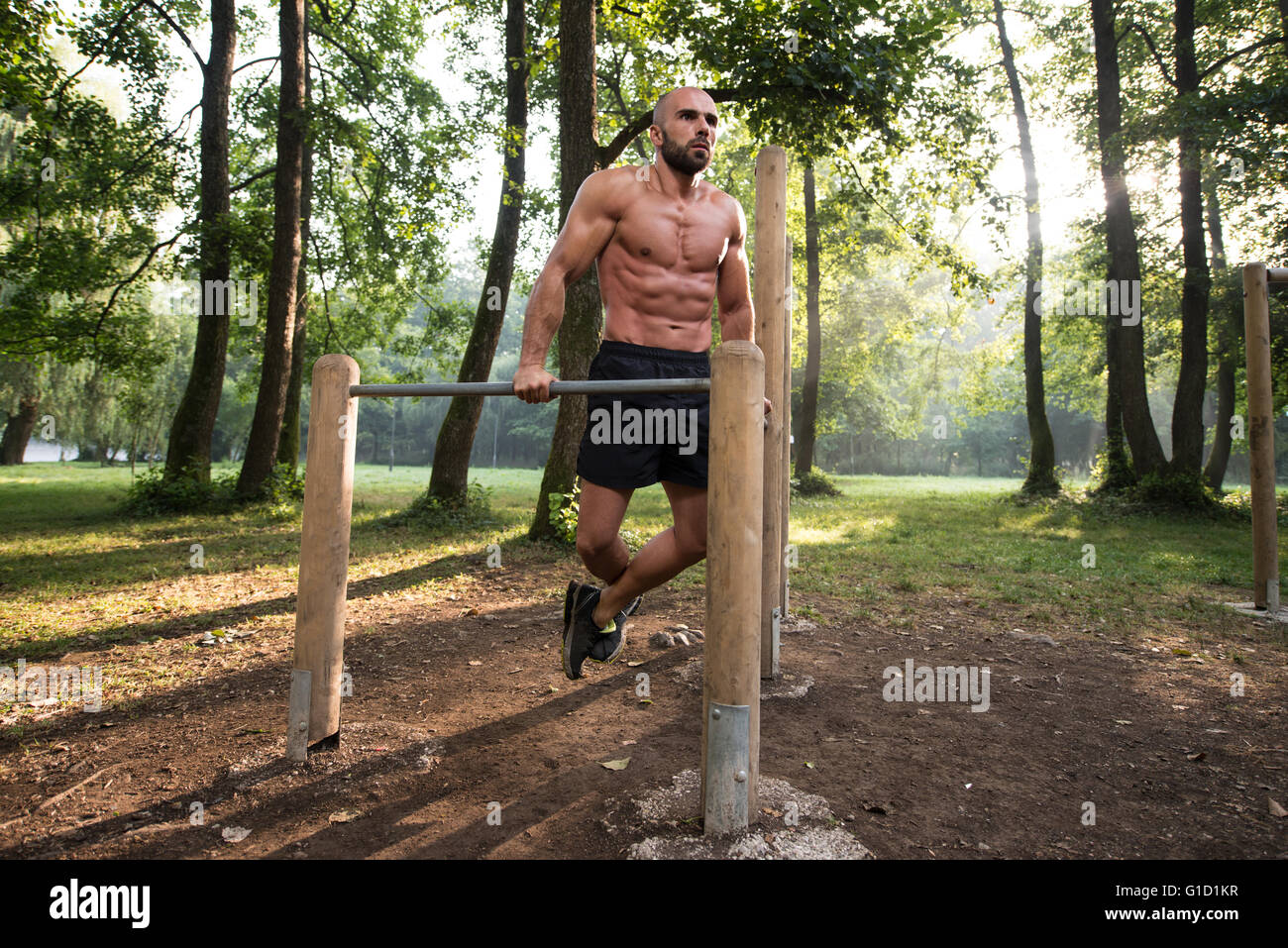 Young Athlete Working Out Triceps In An Outdoor Gym - Doing Street ...