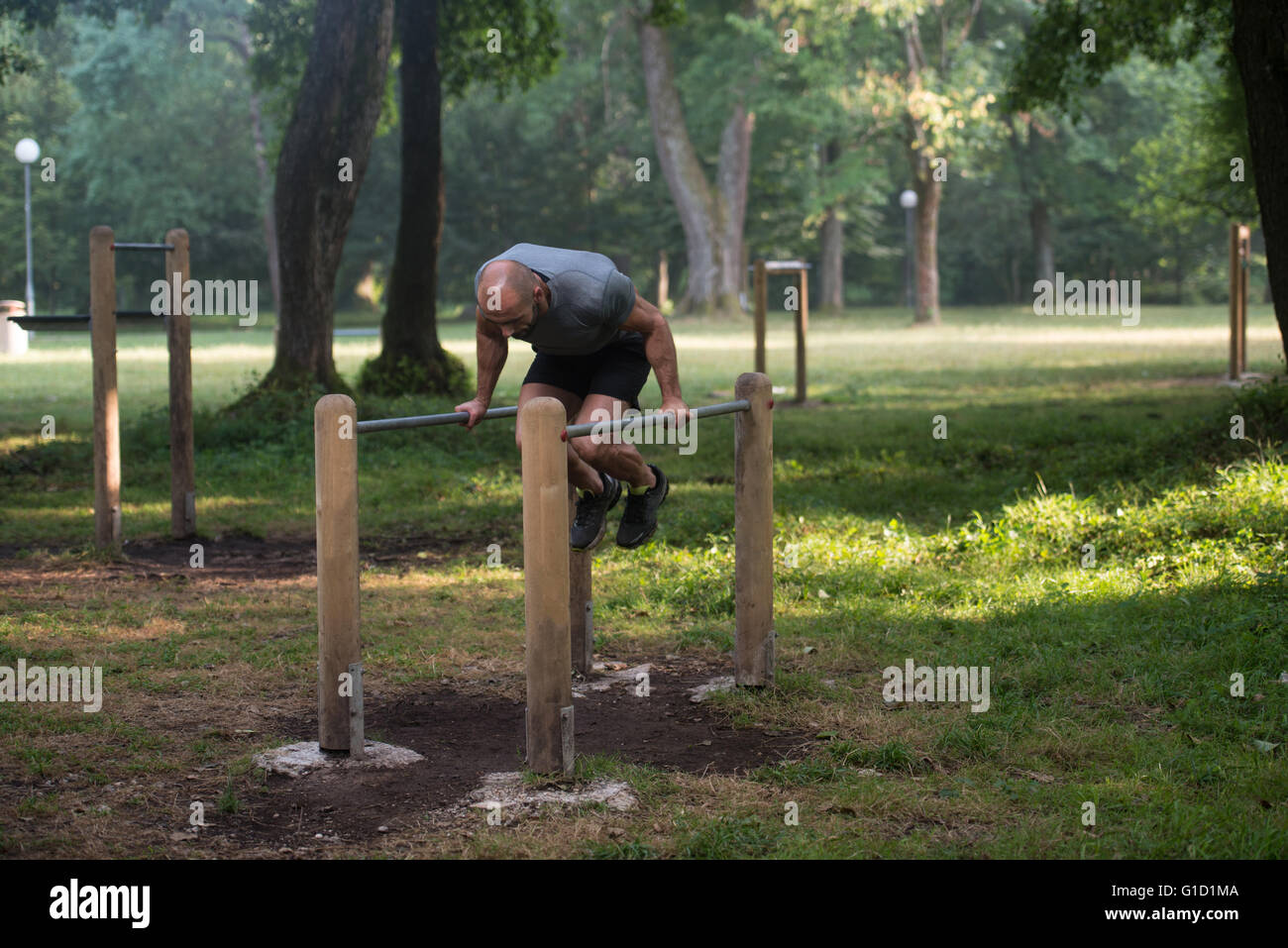 Athlete Working Out Hand Stand On Parallel Bars In An Outdoor Gym ...