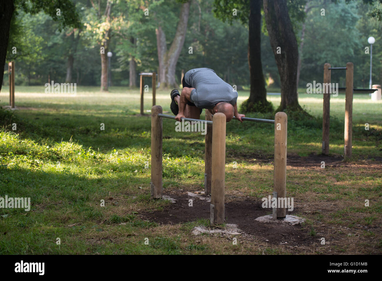 Athlete Working Out Hand Stand On Parallel Bars In An Outdoor Gym ...