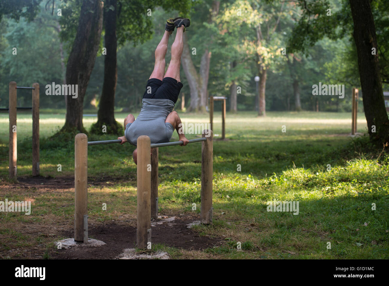 Athlete Working Out Hand Stand On Parallel Bars In An Outdoor Gym ...