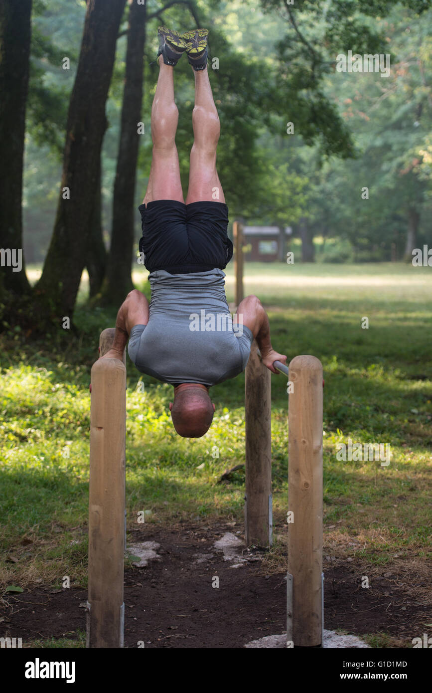 Athlete Working Out Hand Stand On Parallel Bars In An Outdoor Gym ...