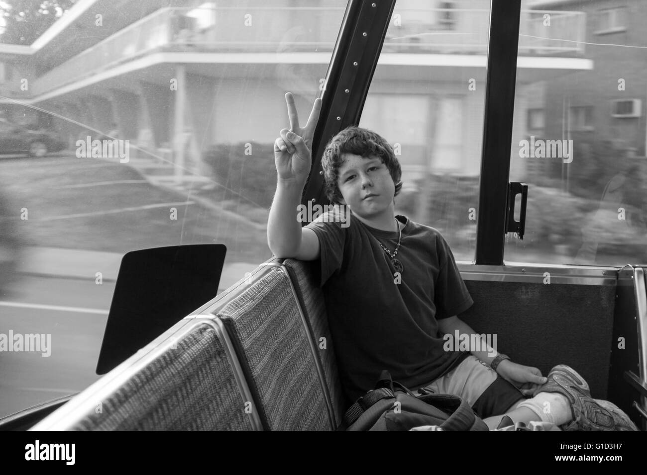 Teenager riding in a bus making the peace sign Stock Photo - Alamy