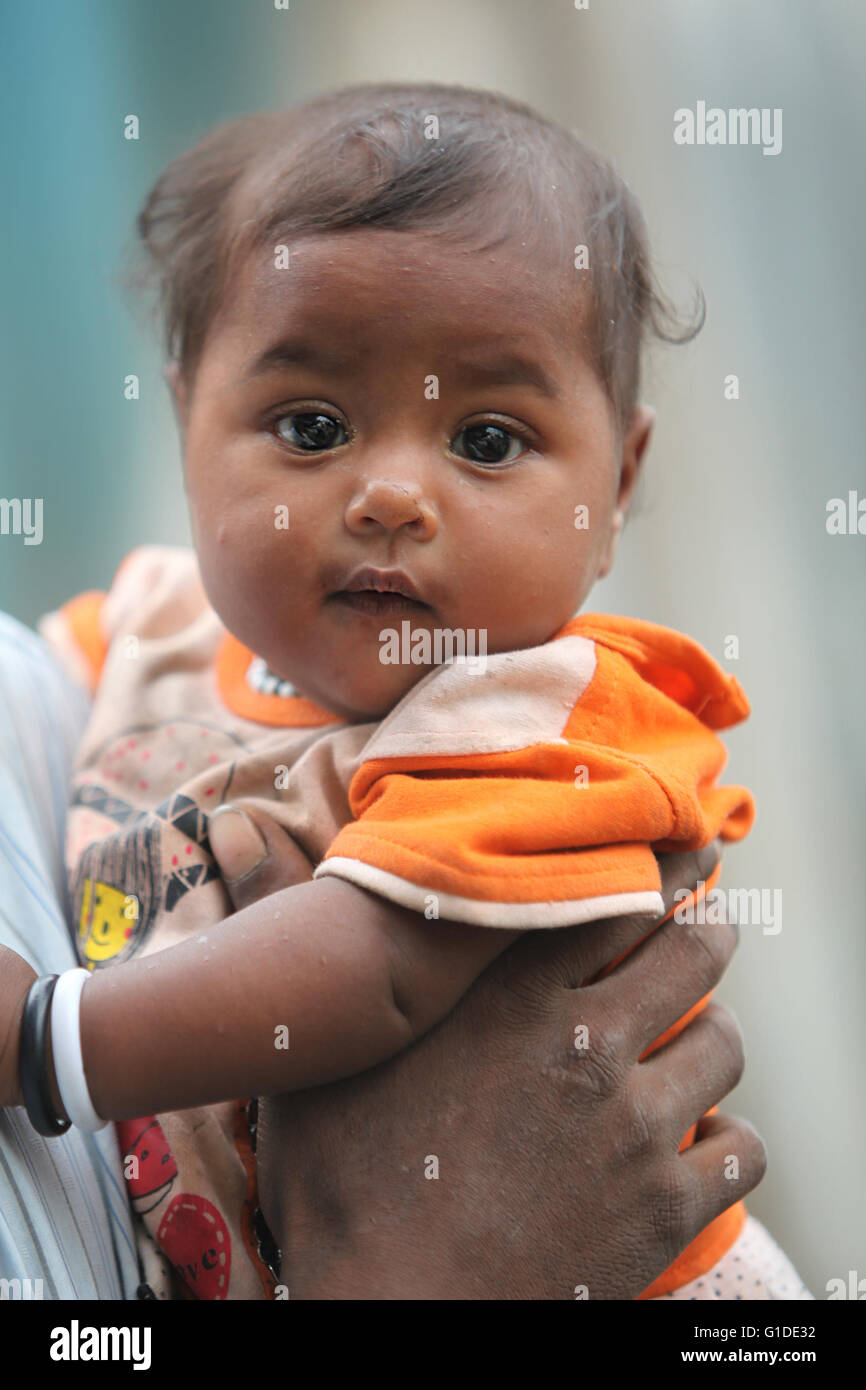 A innocent looking baby in the hands of her poor father Stock Photo - Alamy