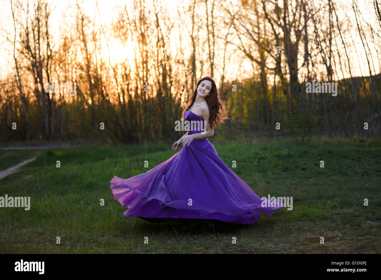 Running attractive girl dressed evening gown at sunset Stock Photo - Alamy