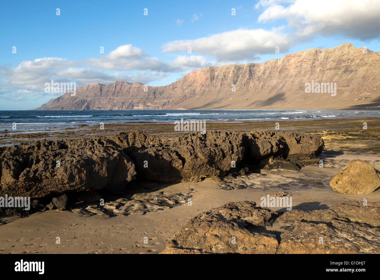 Late afternoon light on beach and cliffs La Caleta de Famara, Lanzarote ...