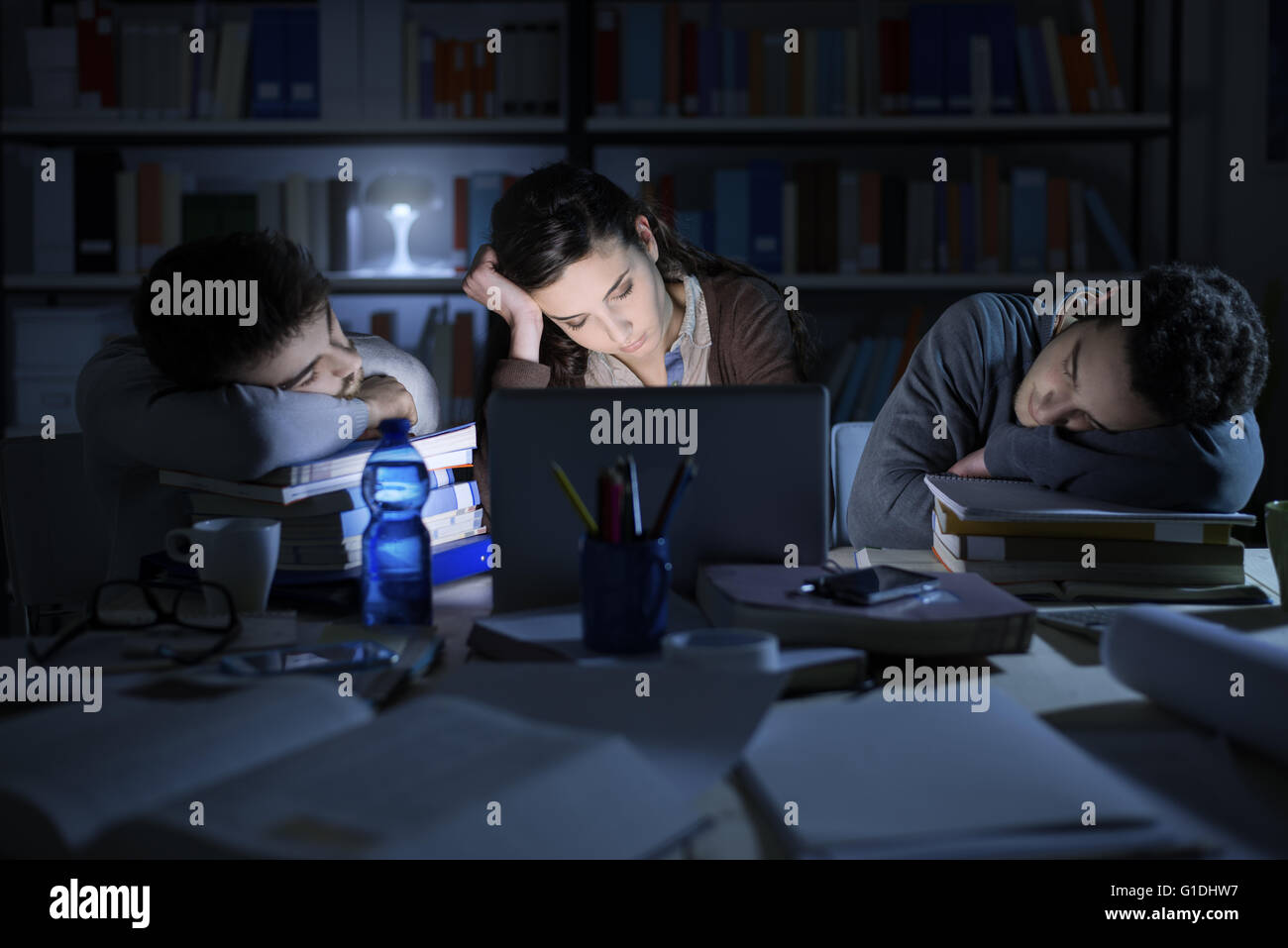 Tired students studying late at night, they are sleeping on the desktop ...