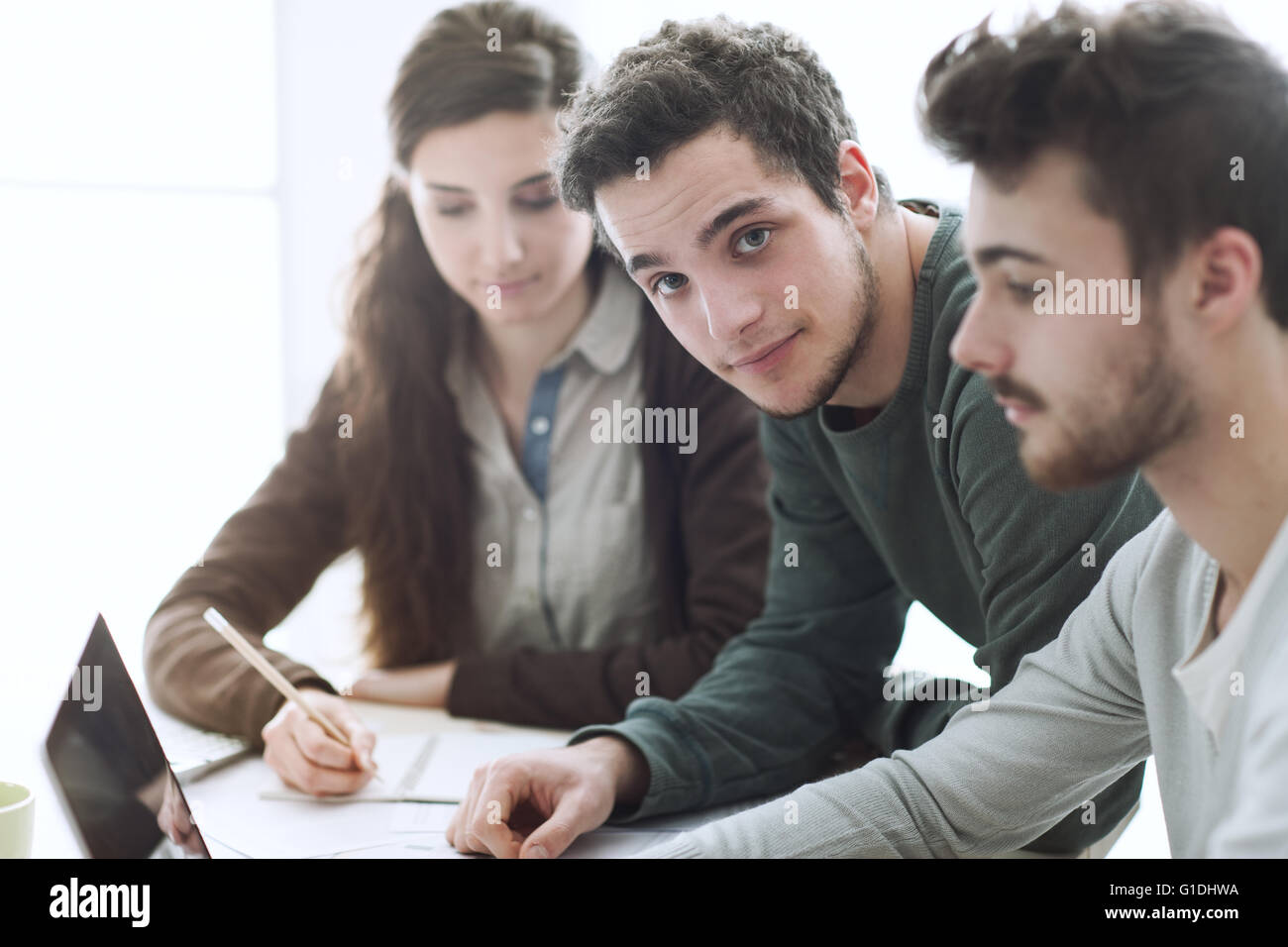 Group of college students at desk using a laptop, networking and ...