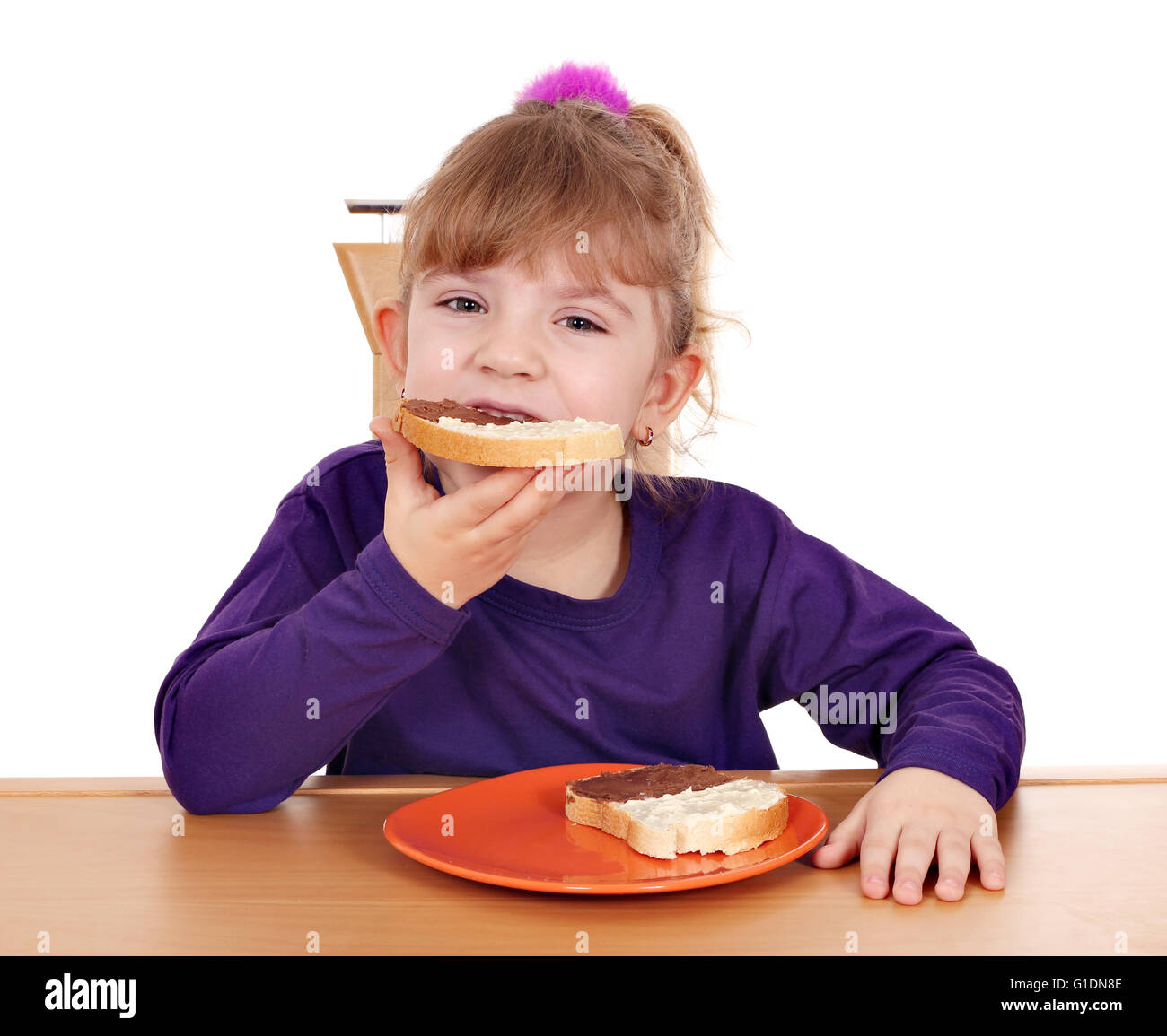 hungry little girl eats bread with chocolate cream Stock Photo - Alamy