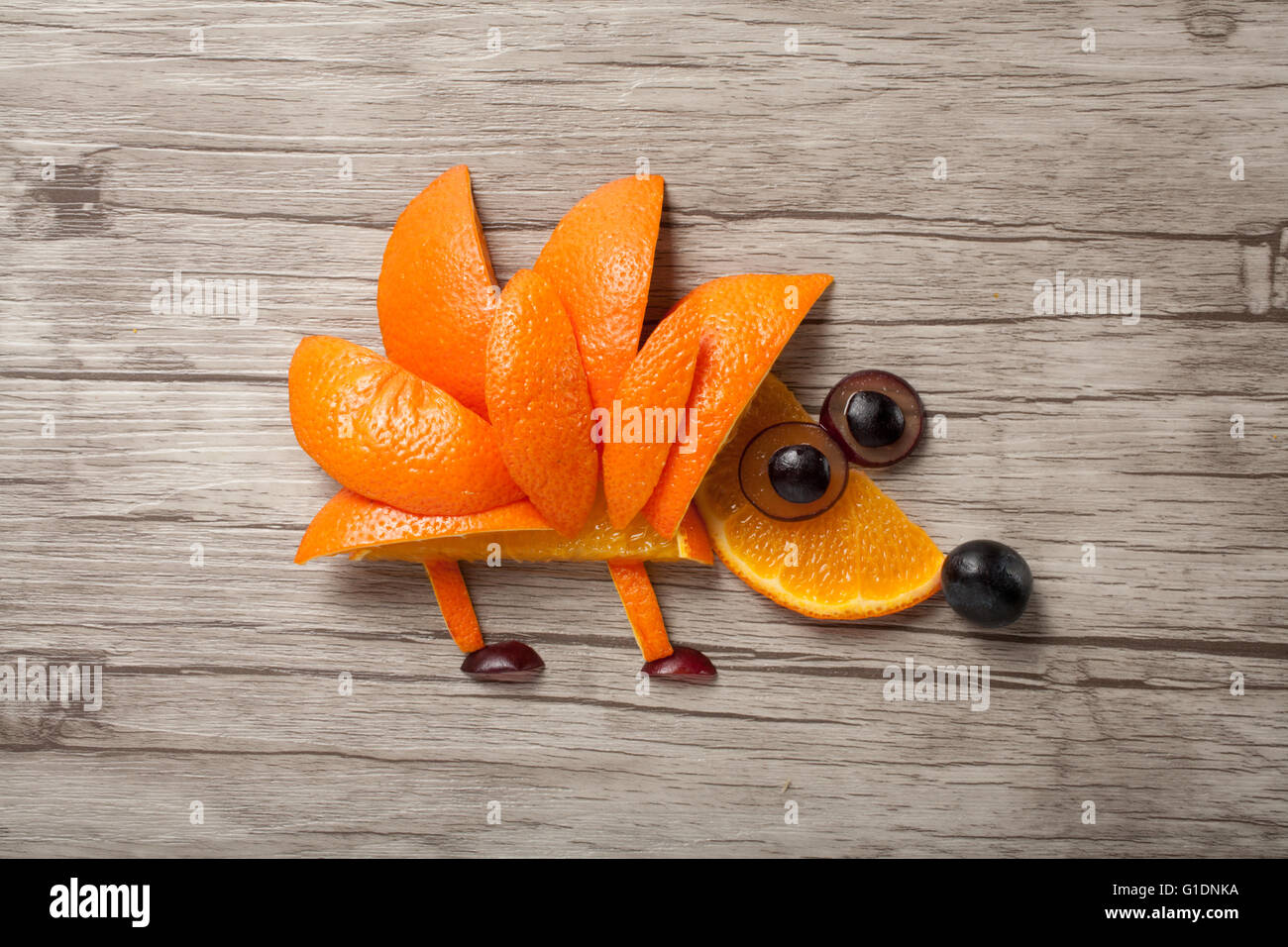 Hedgehog made of orange and grape on wooden desk Stock Photo - Alamy