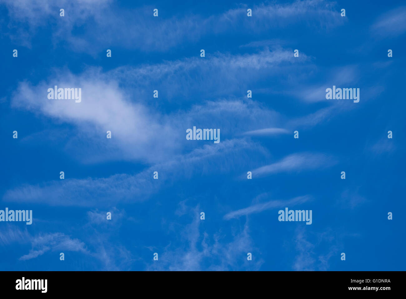 Fluffy, wispy clouds against blue sky background Stock Photo - Alamy