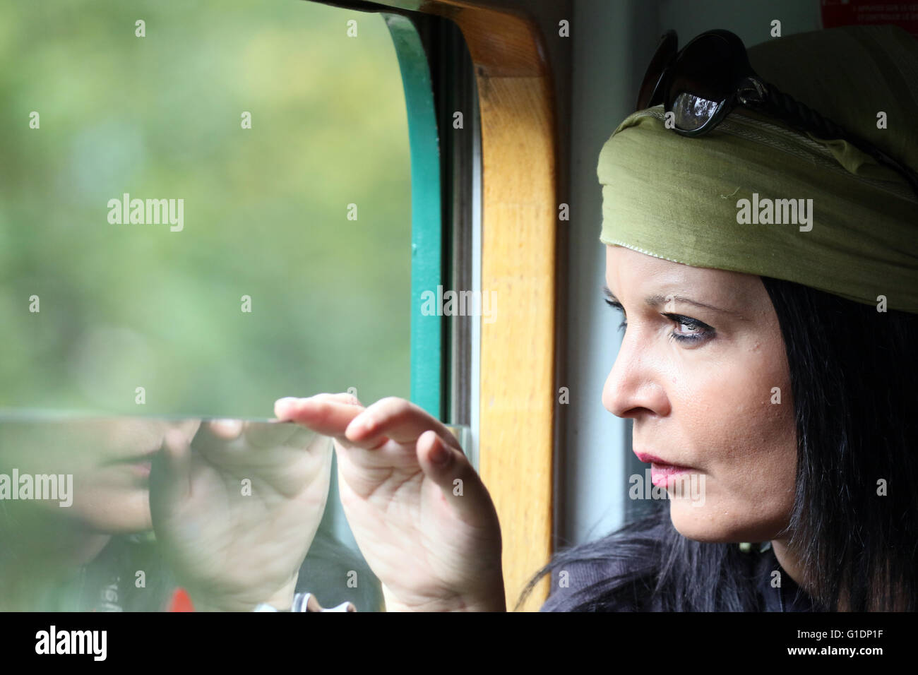 Woman looking outside a window Stock Photo - Alamy