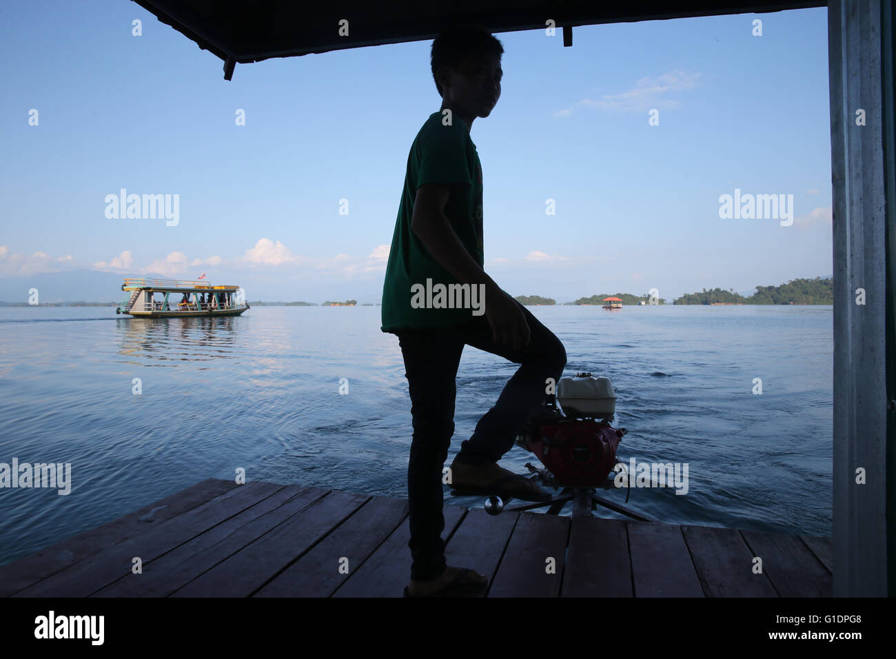 Nam Ngum lake. Boy steering a traditional Lao motor boat. Laos Stock ...