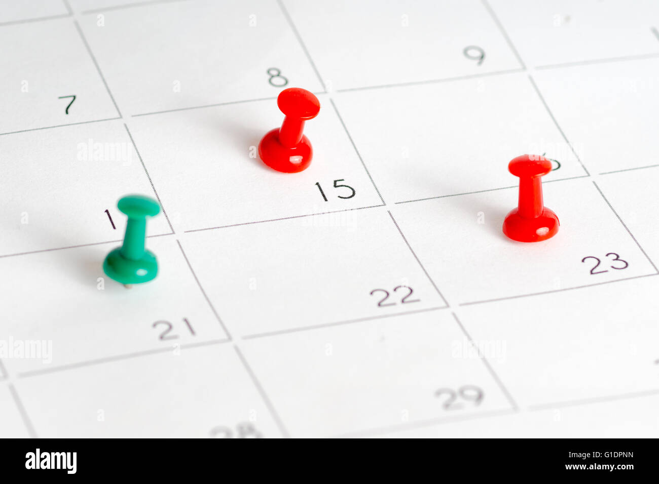 green red pins on calendar grid Stock Photo - Alamy