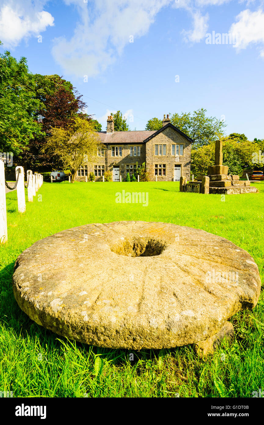 Old millstone with stocks and stump of cross behind at Bolton-by ...