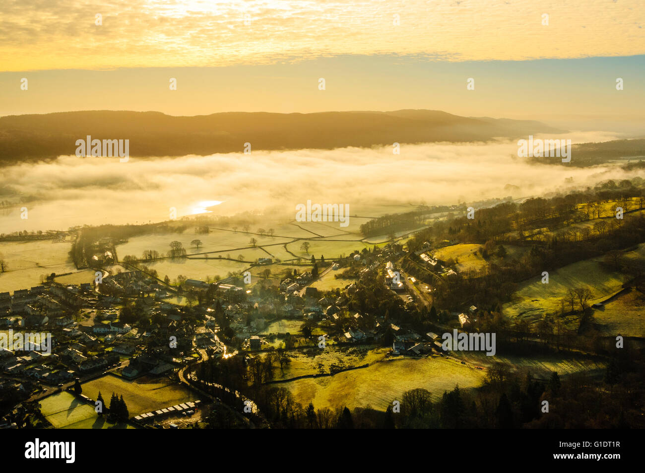 Coniston village in the Lake District with mist over Coniston Water ...
