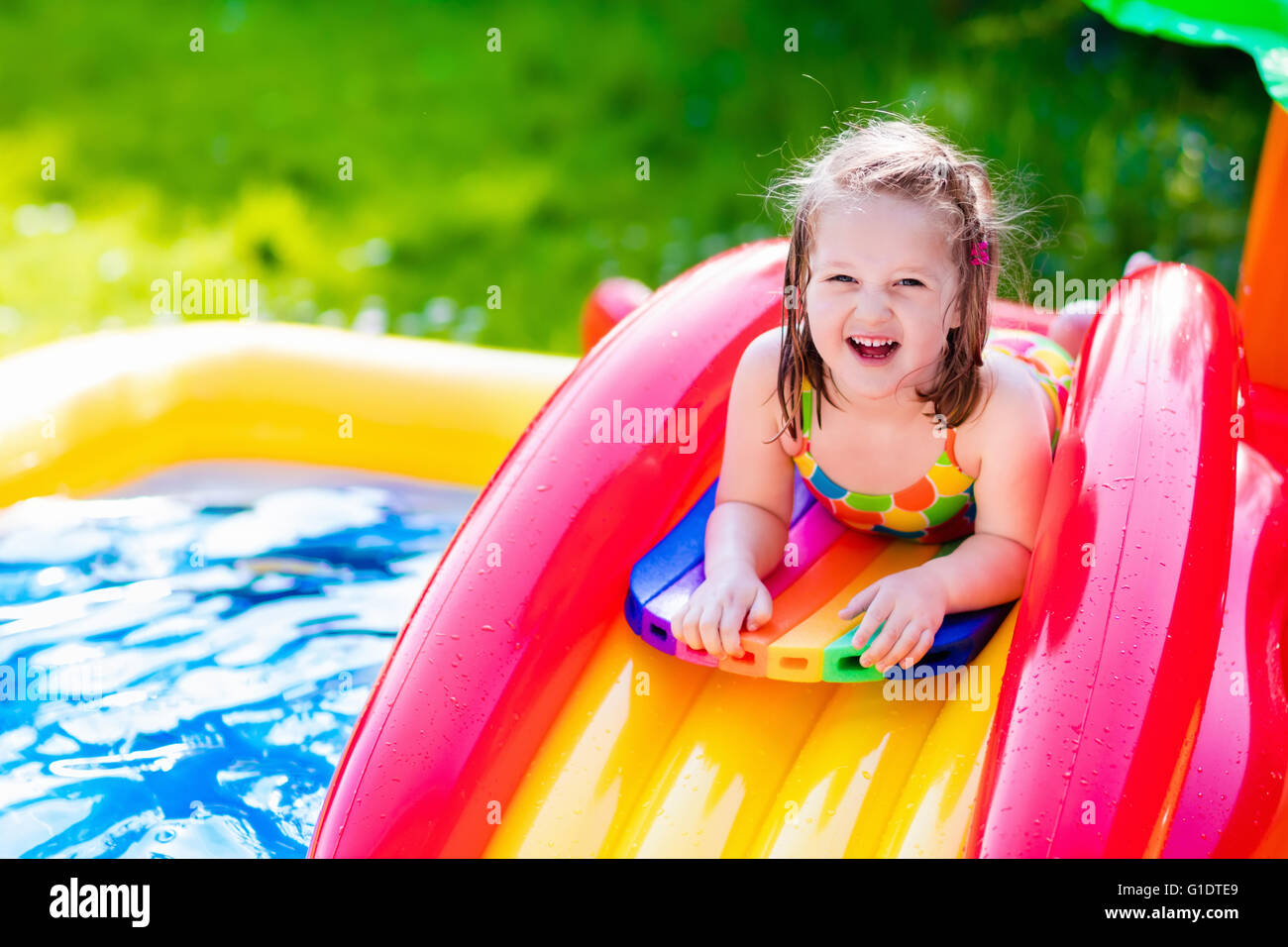 Children playing in inflatable baby pool. Kids swim and splash in ...
