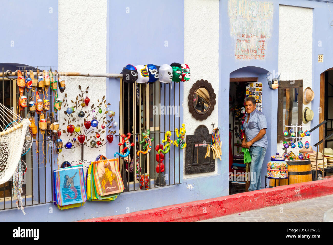 A Mexican shop owner stands in the doorway of his souvenir shop in ...