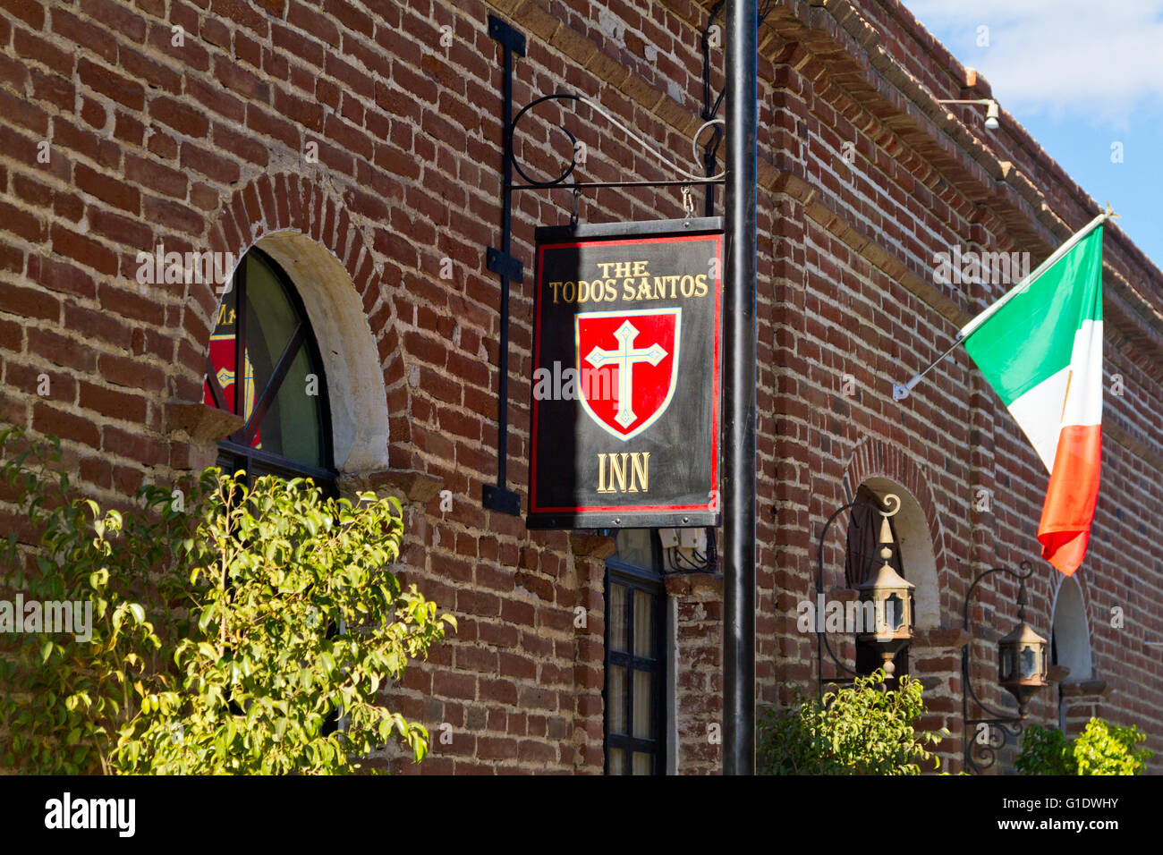 Sign hanging on a red brick wall outside the Todos Santos Inn, Baja ...
