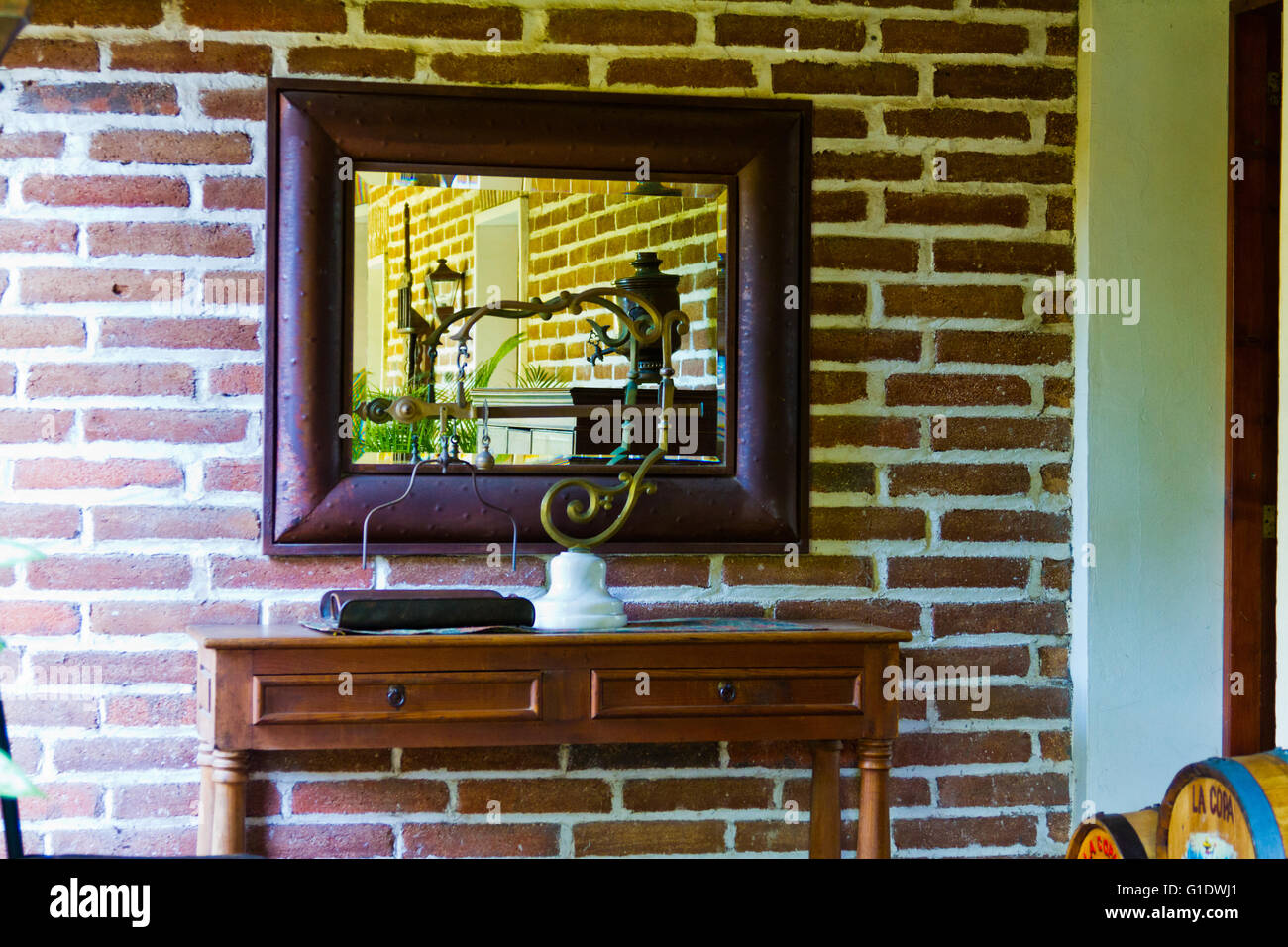 An antique balance scale is reflected in a mirror against a red brick ...