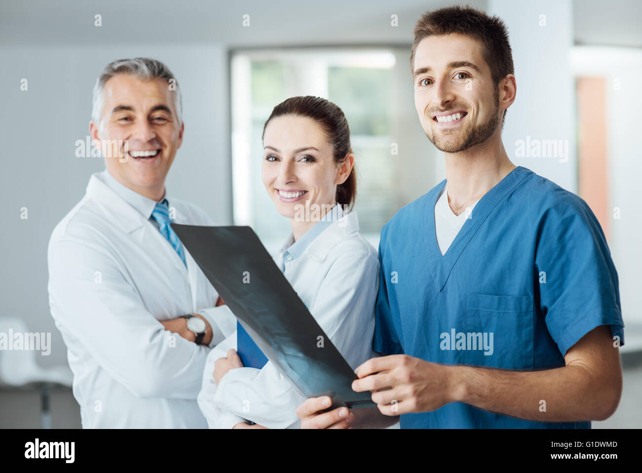 Medical team composed of doctors and surgeon smiling at camera and ...
