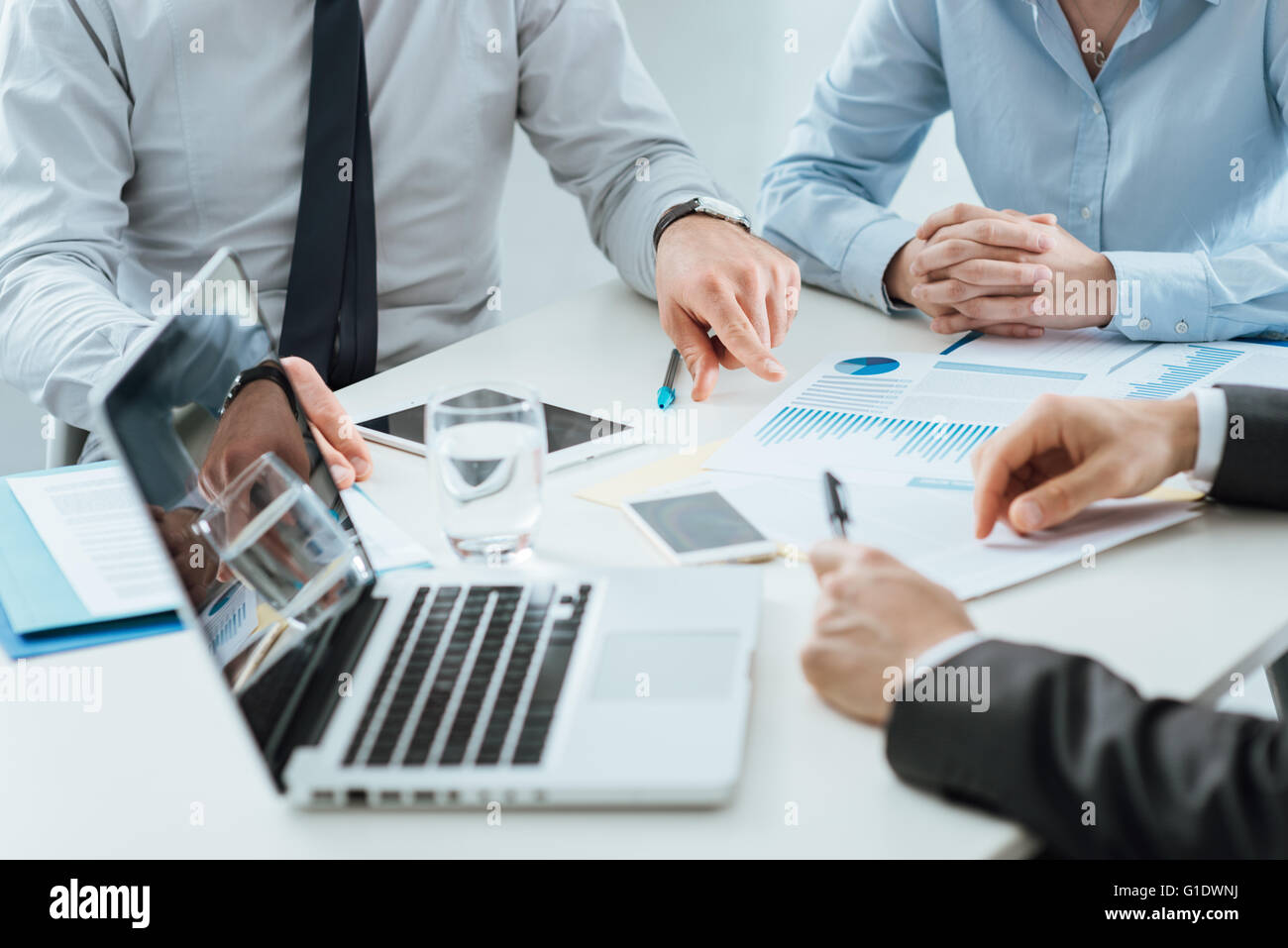 Professional business team working together at office desk discussing ...